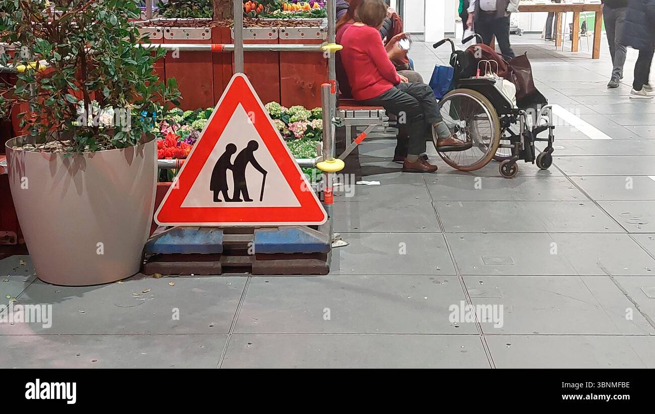 Warning sign: Senior citizens crossing - placed next to park bench with ...