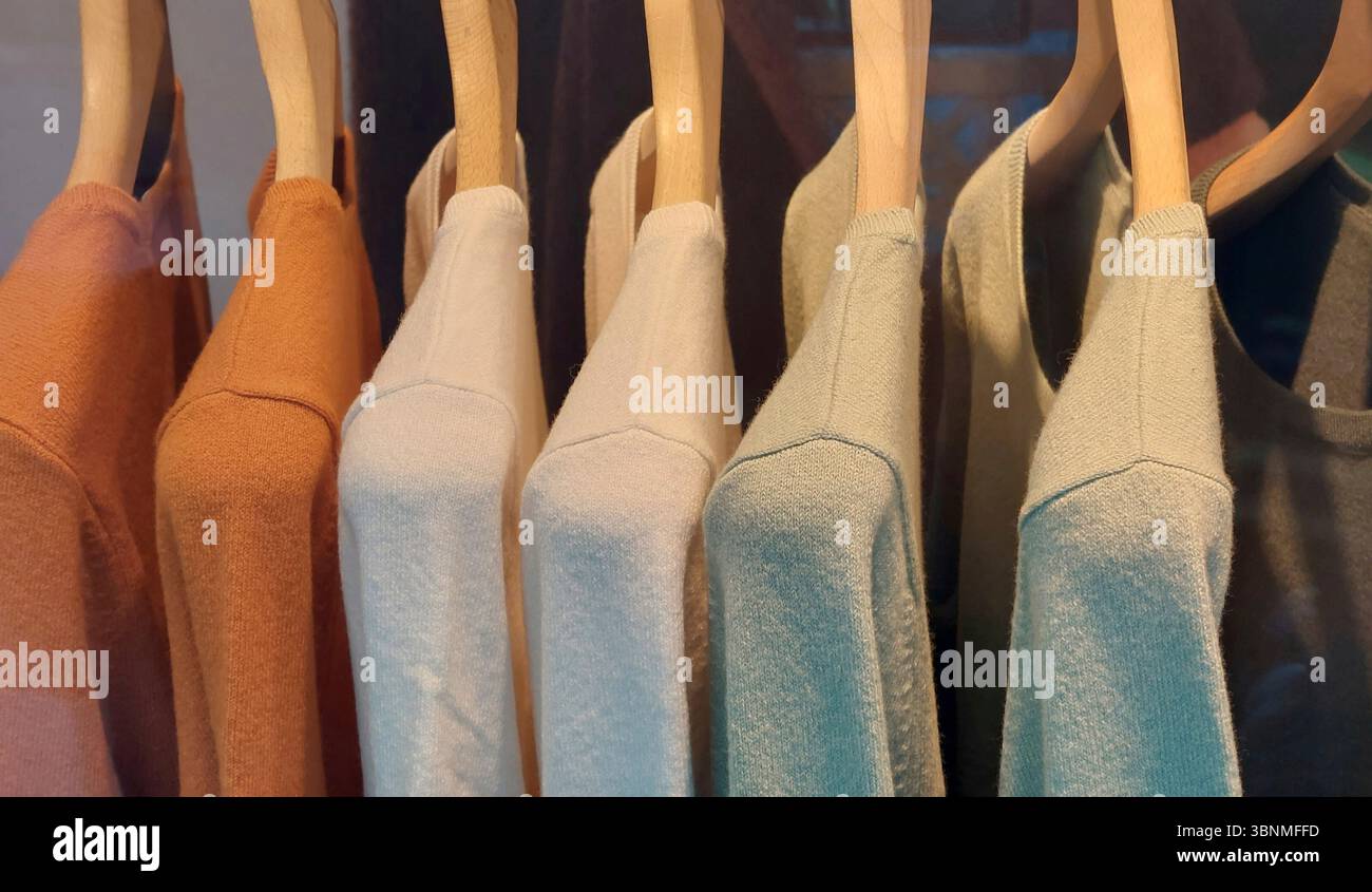 Jackets and coats hung on hangers on clothes rail Stock Photo - Alamy