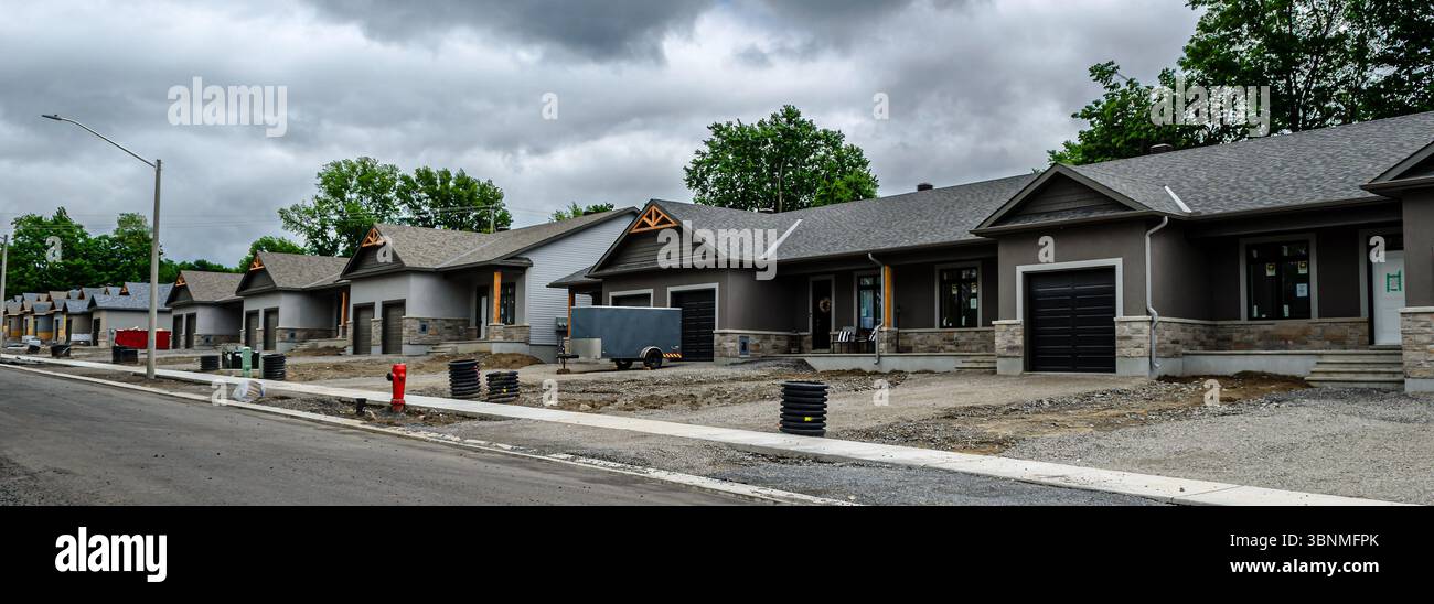 Panorama of newly built row houses in a subdivision under a cloudy sky ...