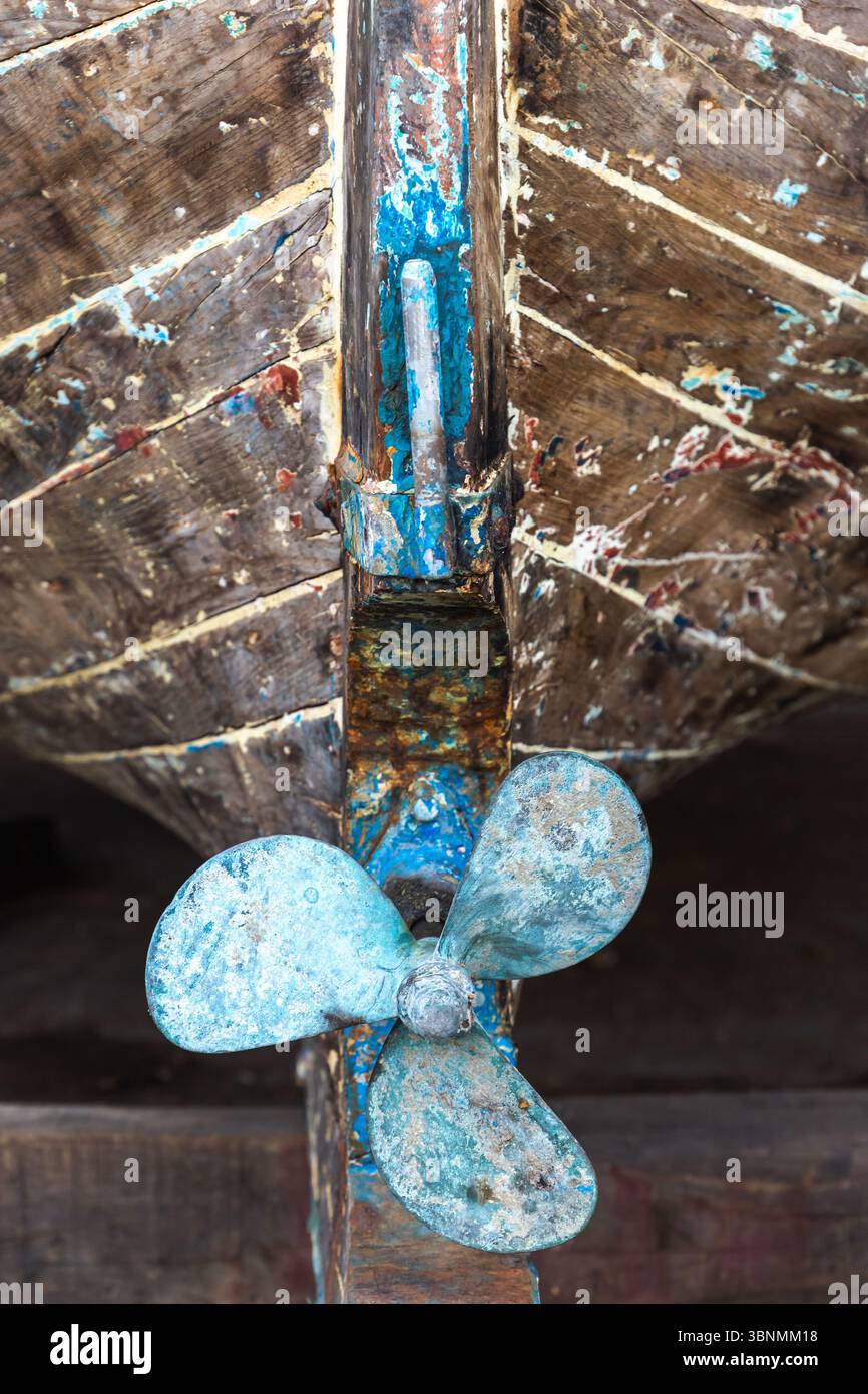 Close-up image of an old wooden boat displaying its weathered propeller ...