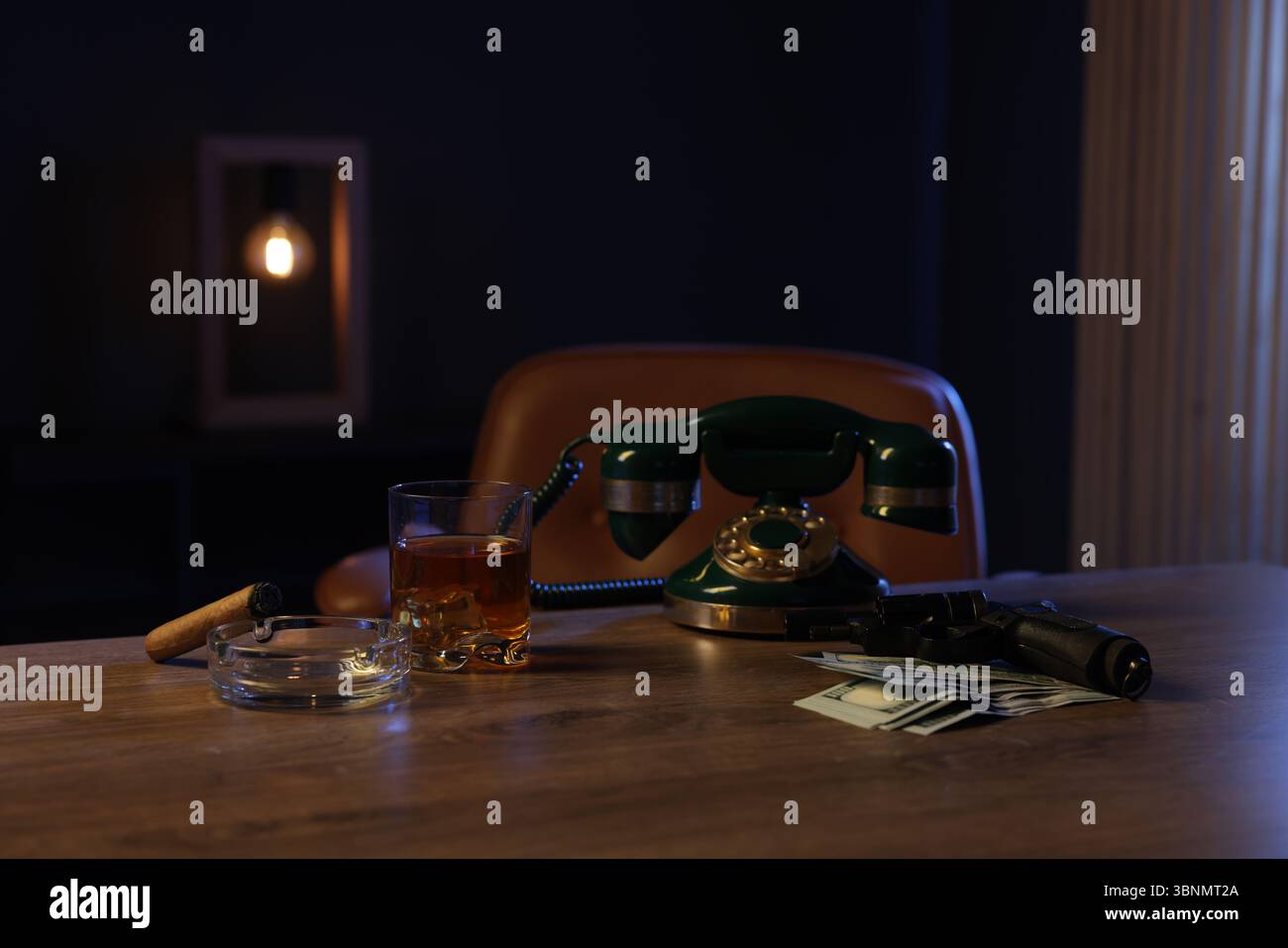 Gun, money, whiskey and other stuff on wooden table in mafia boss ...