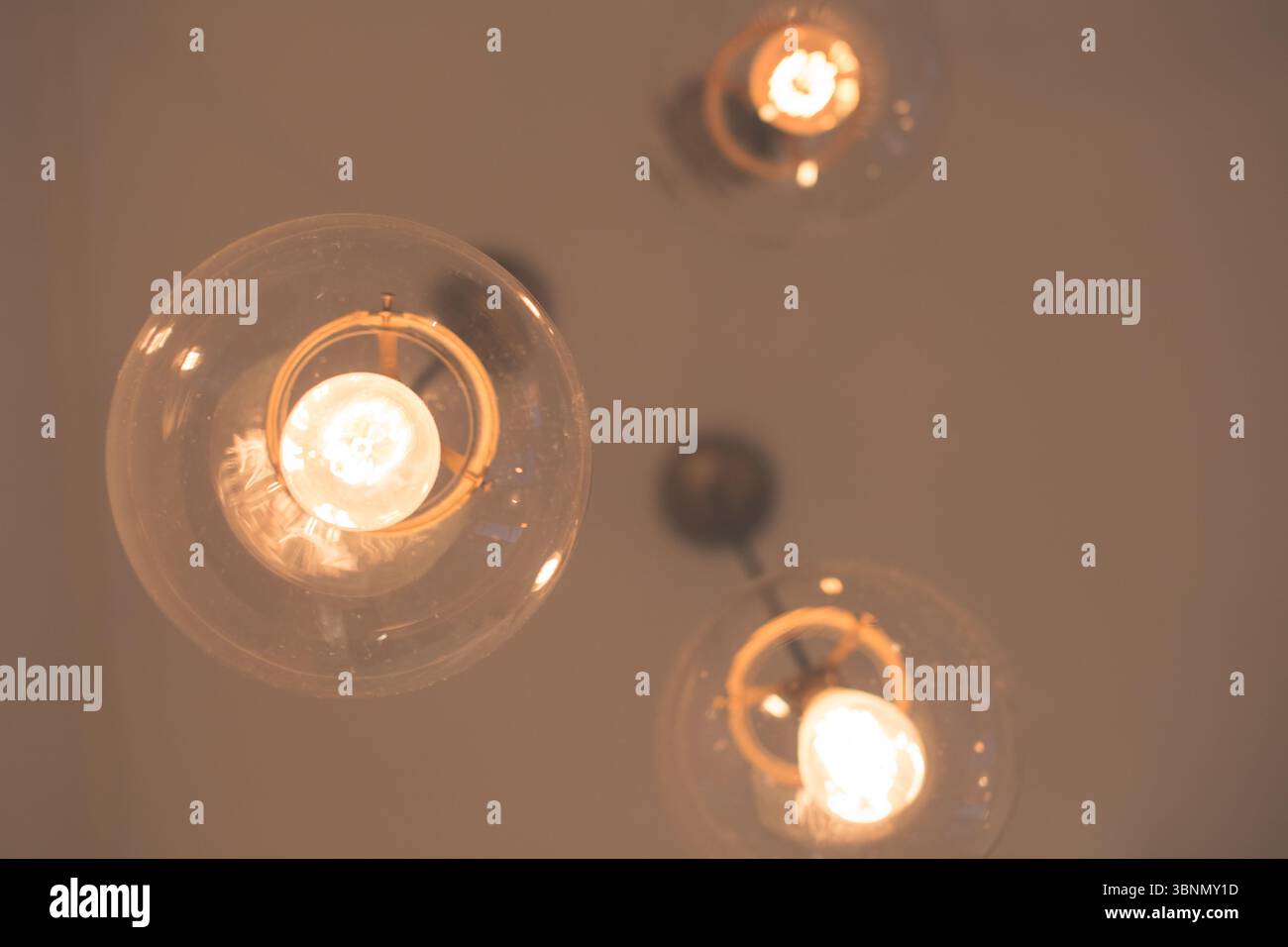 Stylish glass pendant lights illuminate hi-res stock photography and ...