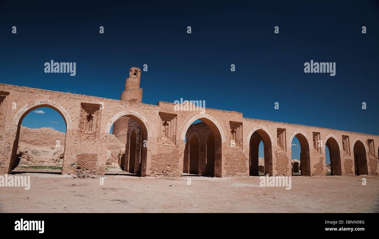 Ancient brick structures with arches stand amidst a barren landscape in ...