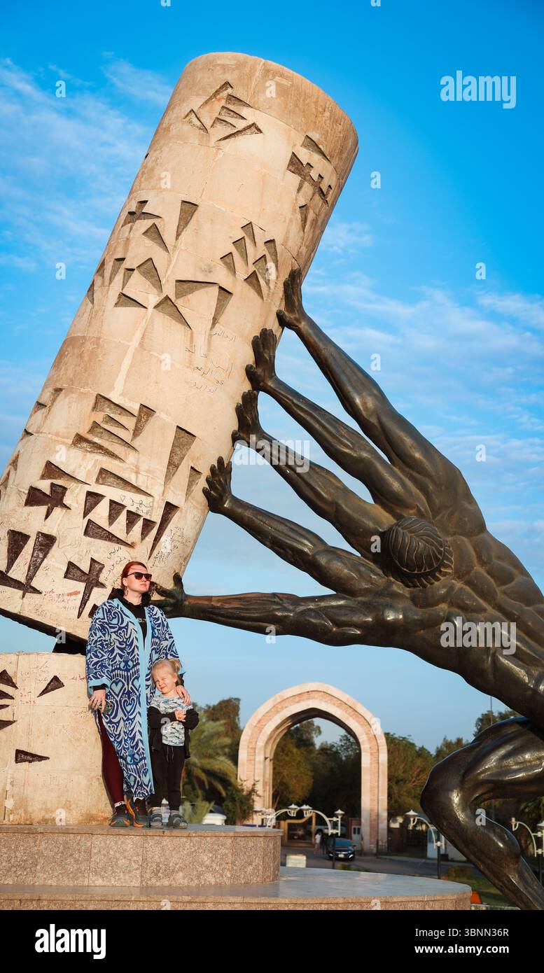 A traveler poses with a child next to a striking monument in Iraq ...