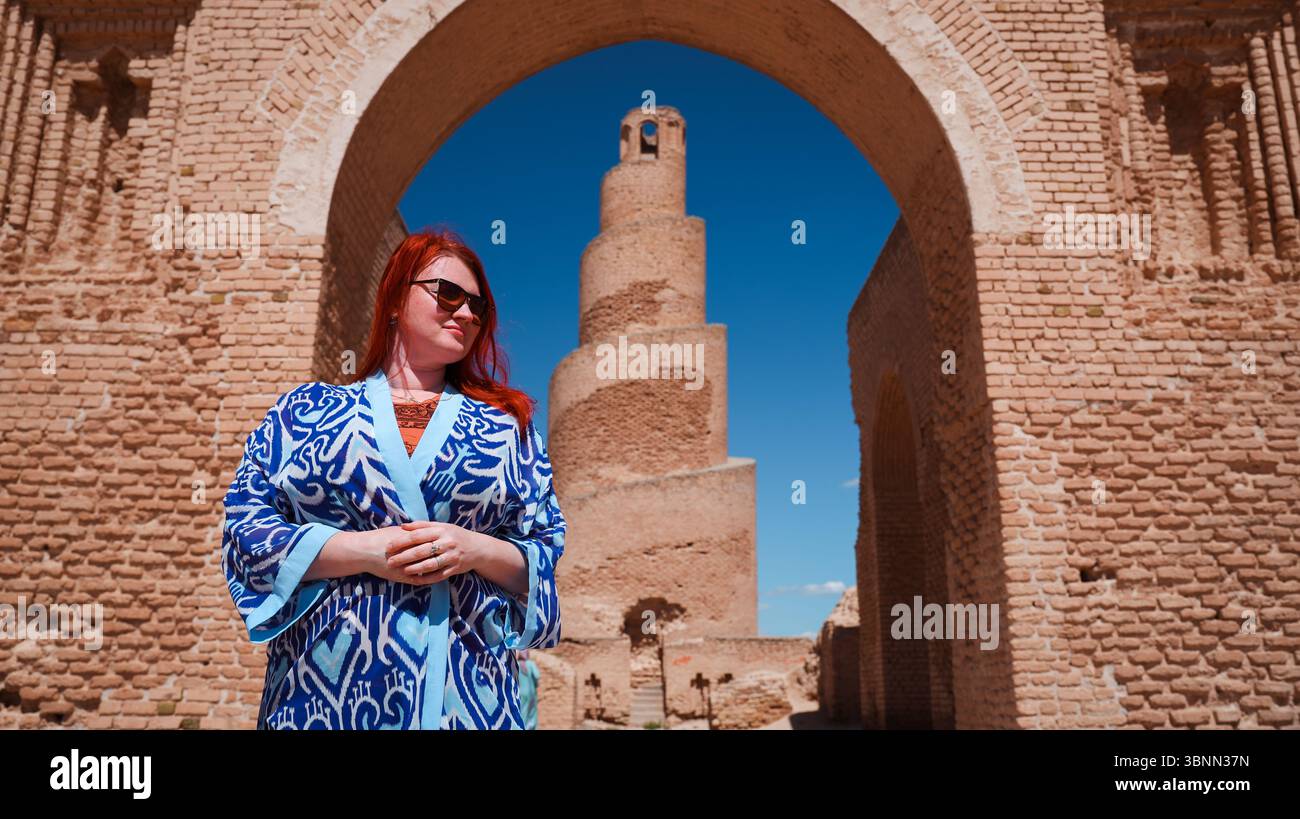 A traveler stands gracefully in traditional attire, admiring the ...