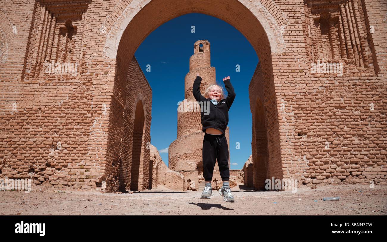 A child enjoys a moment of joy by jumping in front of ancient ruins in ...