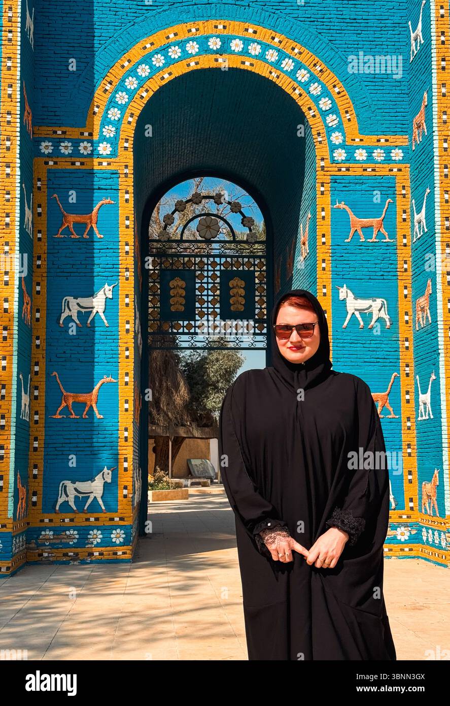 A woman in traditional dress stands at the entrance of a historic site ...