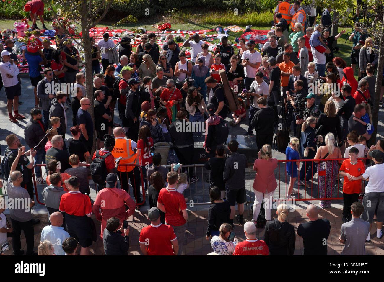Football fans stand next to tributes in memory of Liverpool player ...