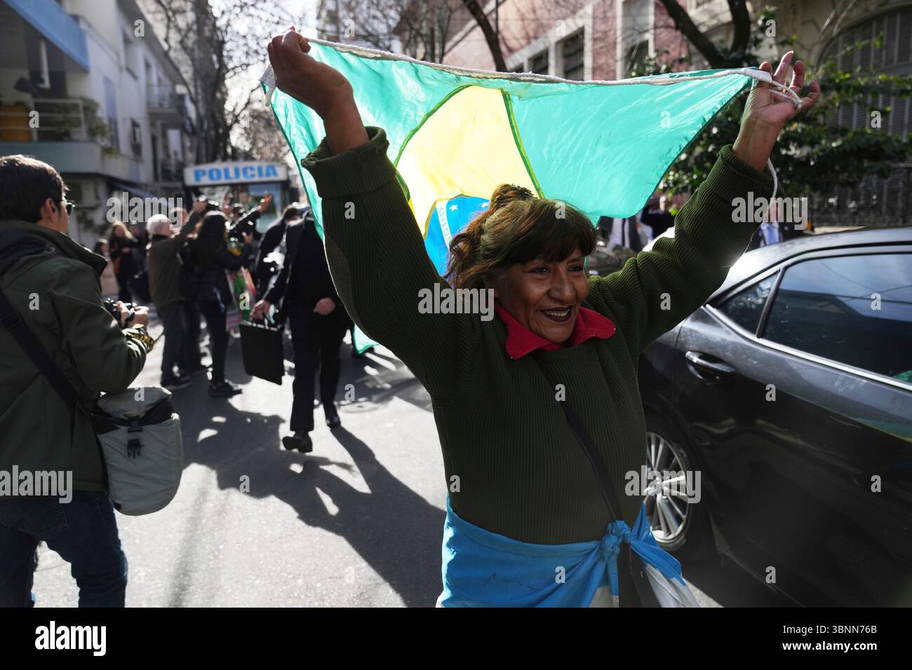 A woman carries a Brazilian flag outside the home of former President ...