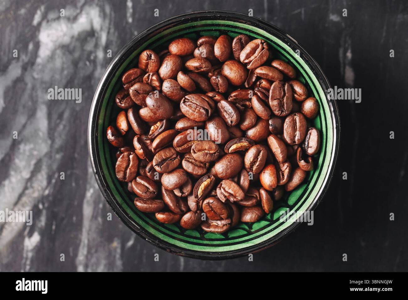 Roasted coffee beans in bowl. Brown aromatic beans on dark background ...