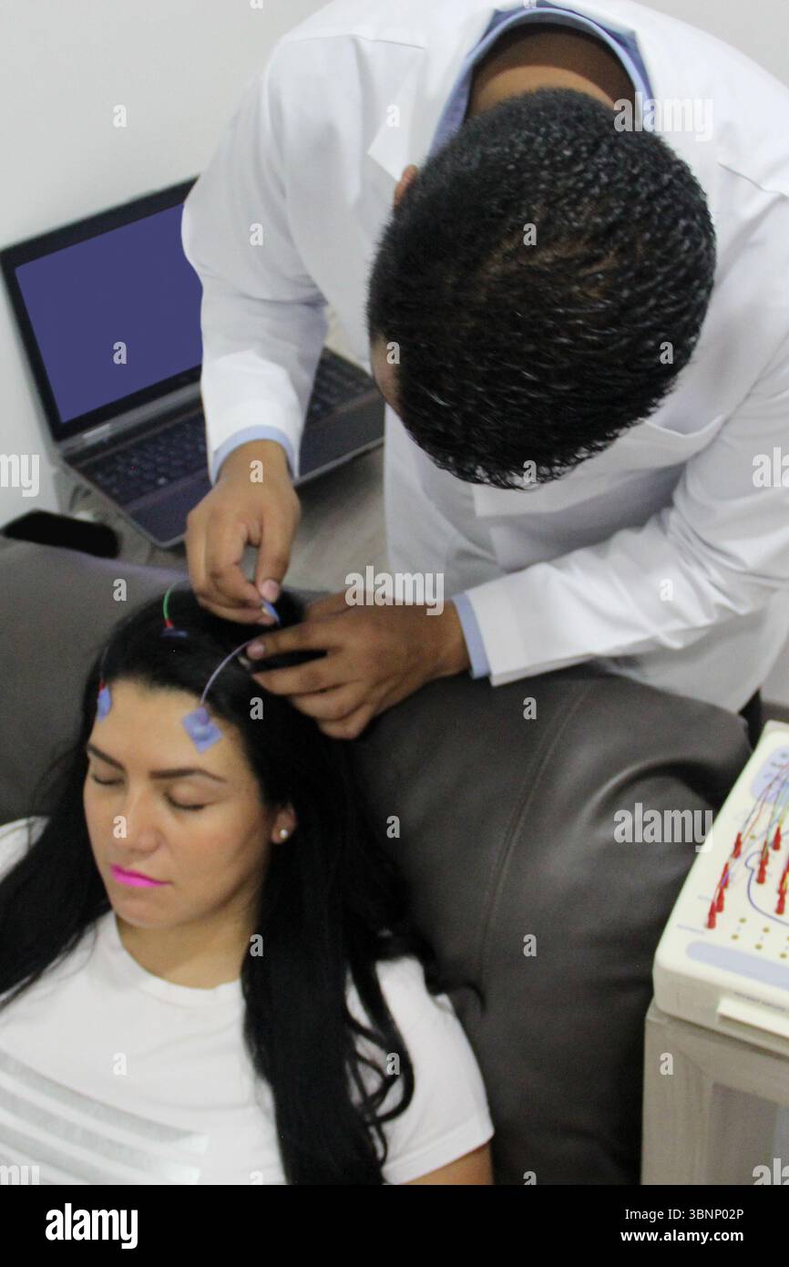 Electroencephalogram, a neurological study of an adult Latina woman with wires on her head to ...
