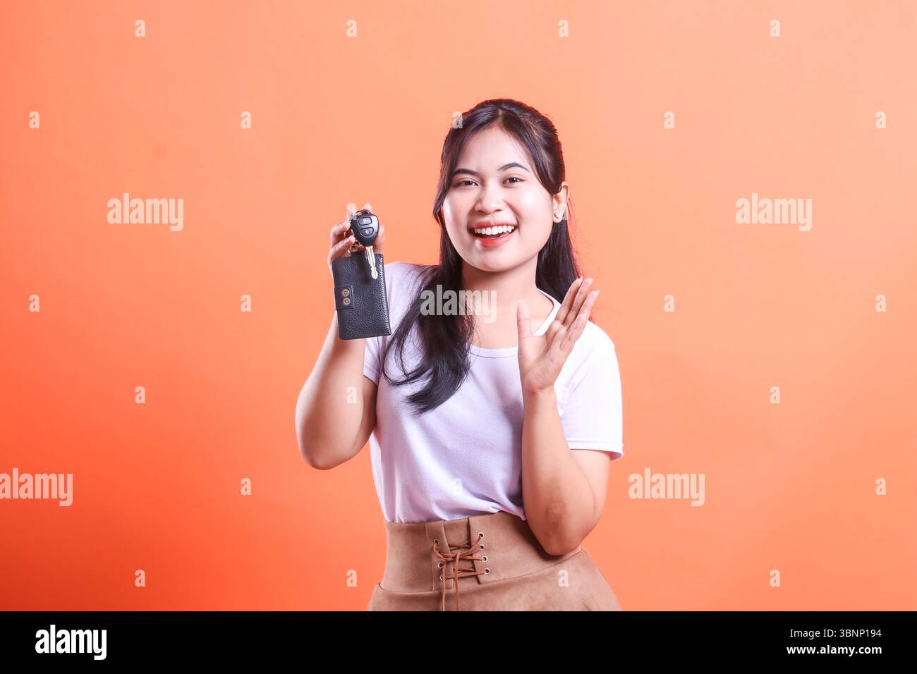 A beautiful and cheerful young woman holding car keys with a big smile ...
