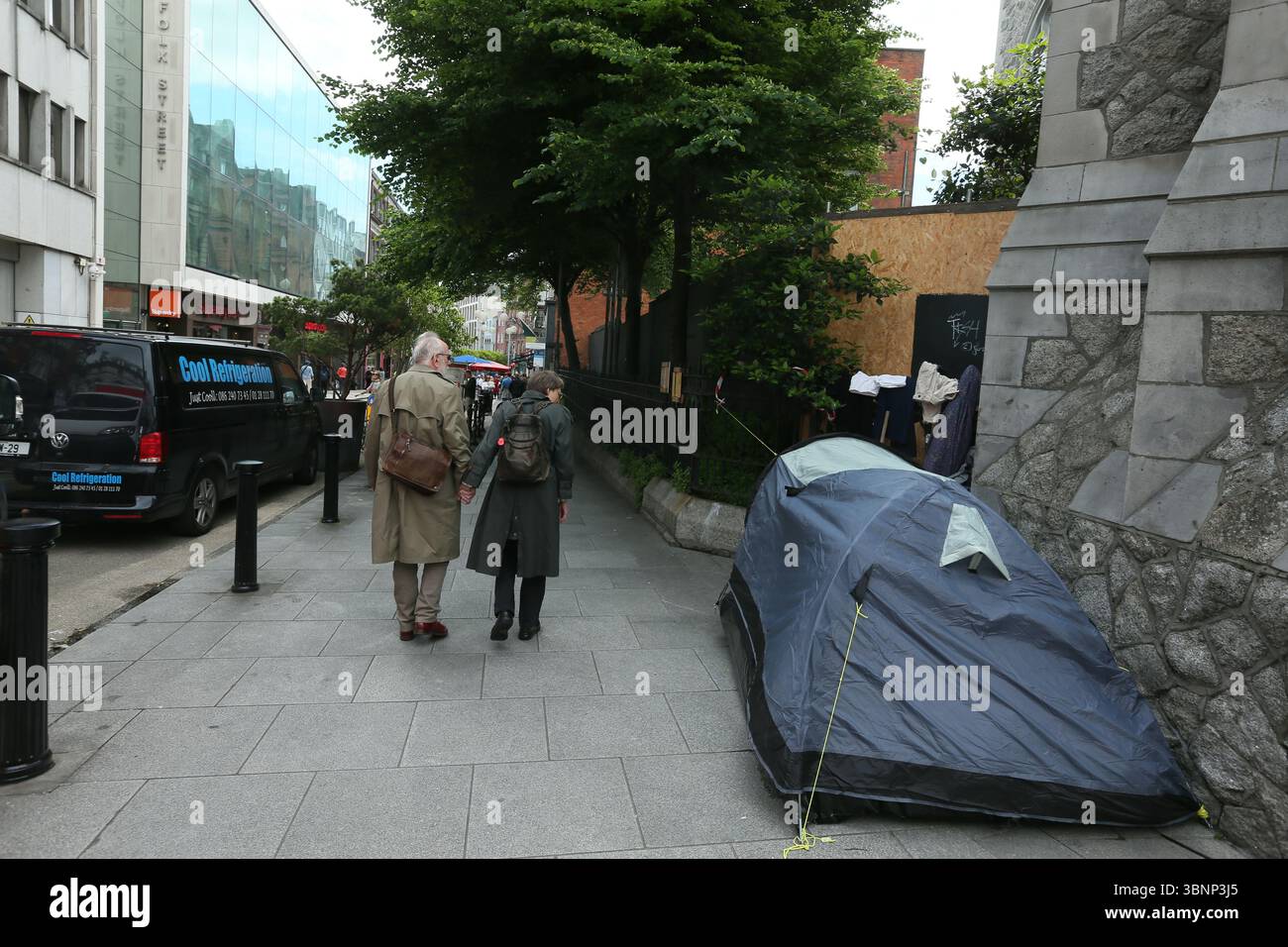 Dublin, Ireland - 30th May 2025 - A couple walk past a homeless person ...