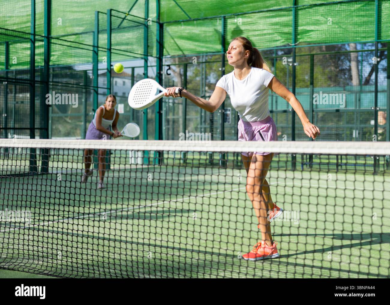 Two women tennis players playing padel Stock Photo - Alamy