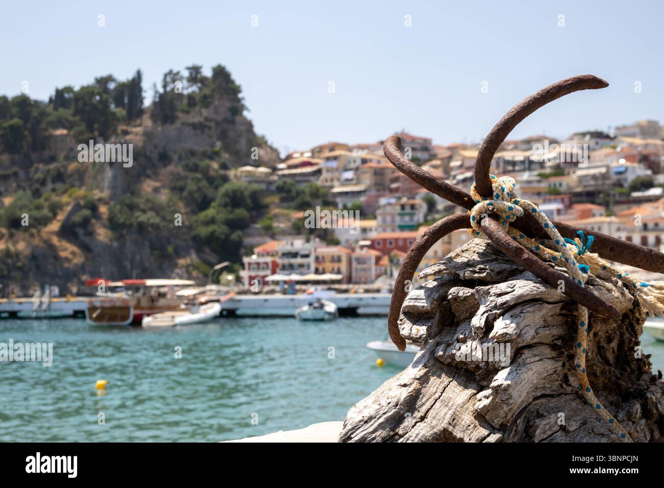 a weathered, rusty anchor secured with blue and yellow ropes to a ...