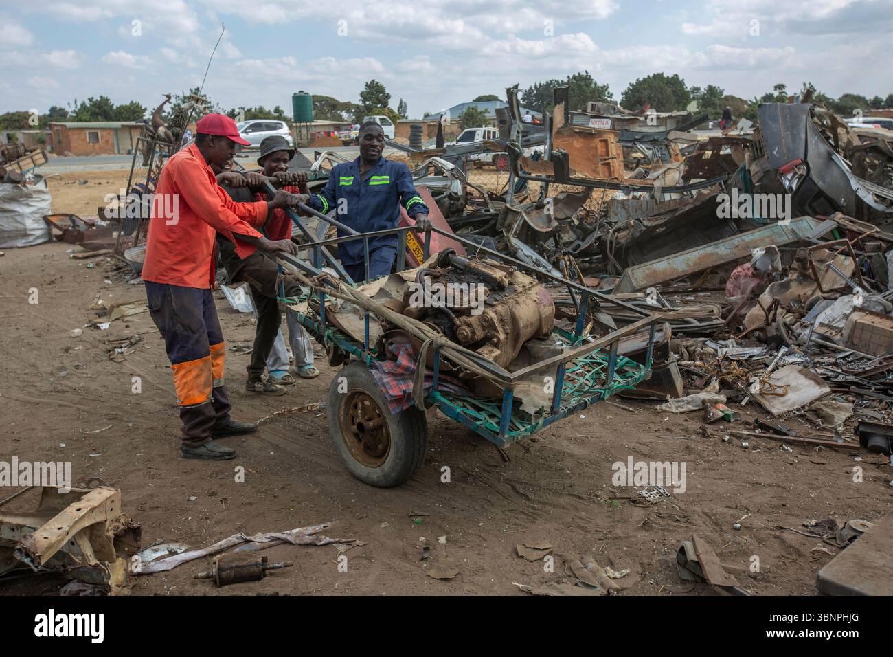 Scrap metal collectors move a piece in Harare, Zimbabwe, Sunday, June 8 ...