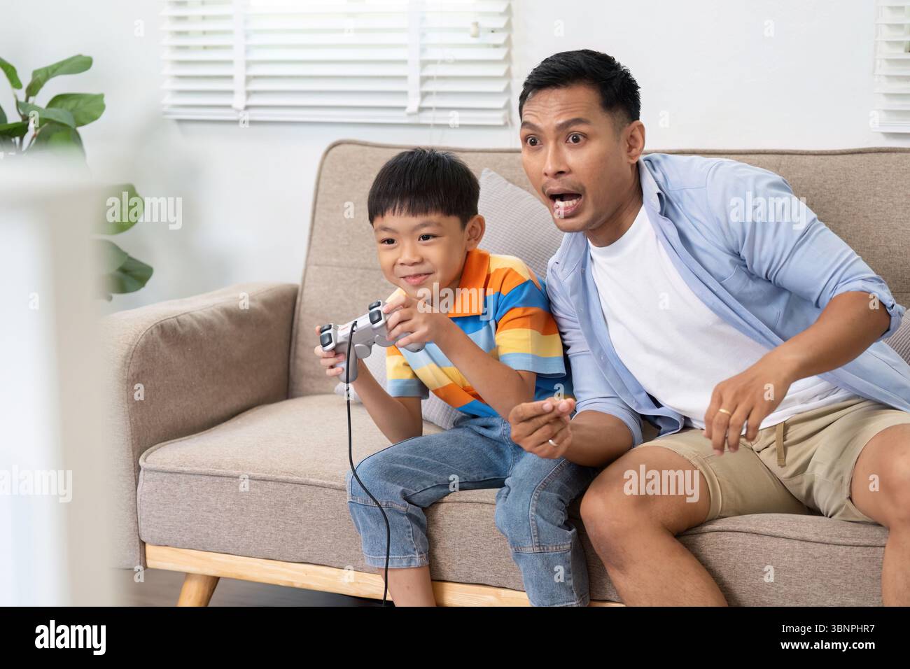 Father and Son Gaming Together. A father and son enjoy an exciting ...