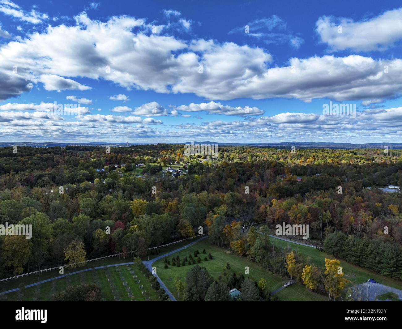 Vast fields and colorful trees stretch across the countryside ...