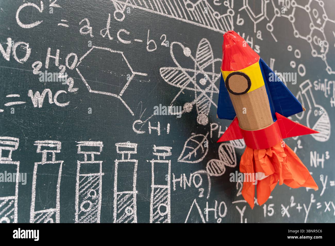 Handmade paper rocket model on chalkboard with chemical and physical ...