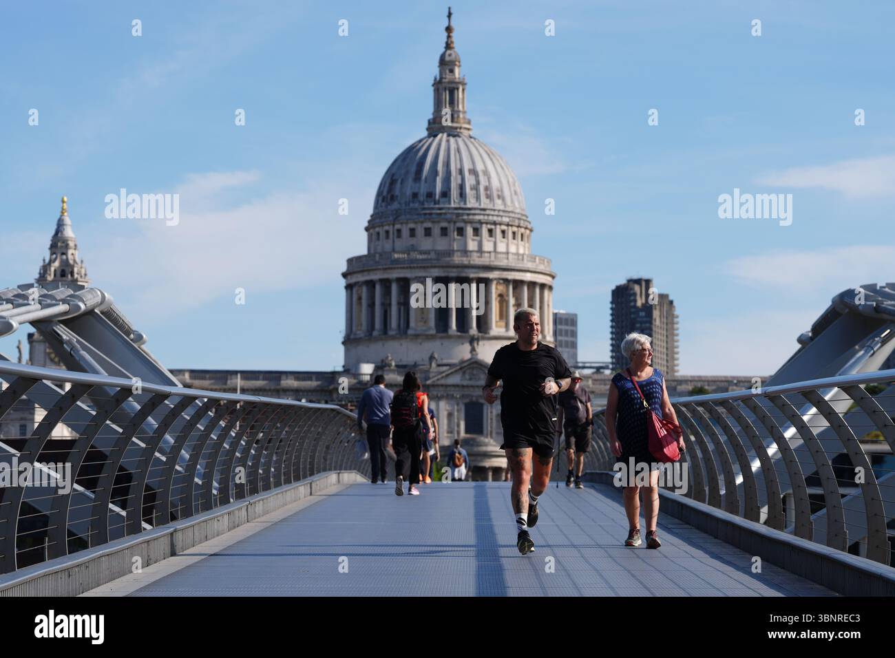 A person runs across the Millennium Bridge in London. Picture date ...