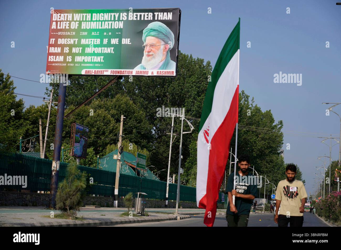 Kashmiri Shiite Muslims walk with Iranian flag near a billboard of Iran ...