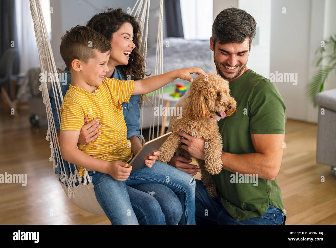 Happy family and kid having fun with smartphone, digital gadget at home ...