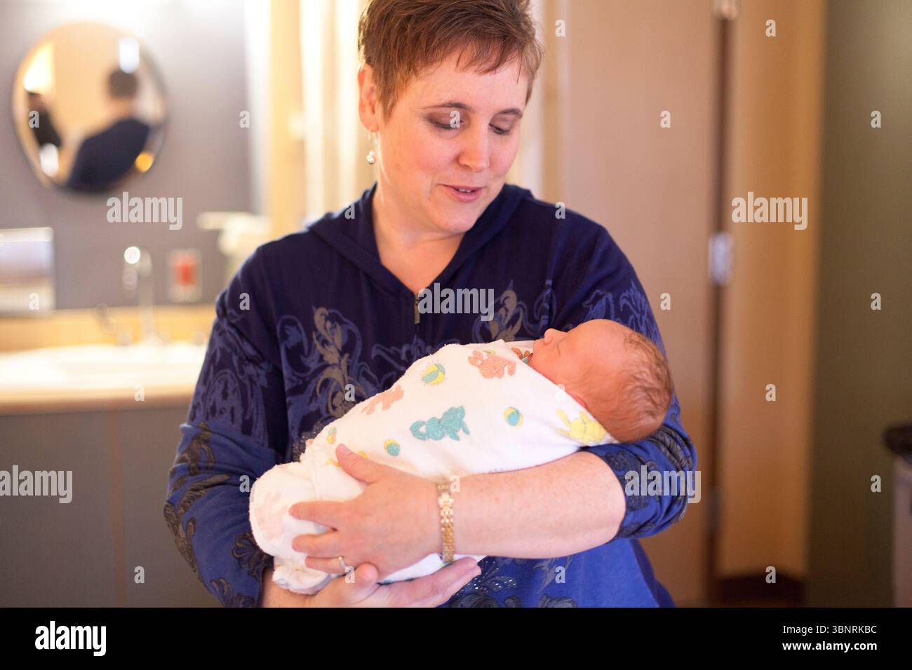 A woman holds a newborn baby in the maternity ward of a hospital Stock ...