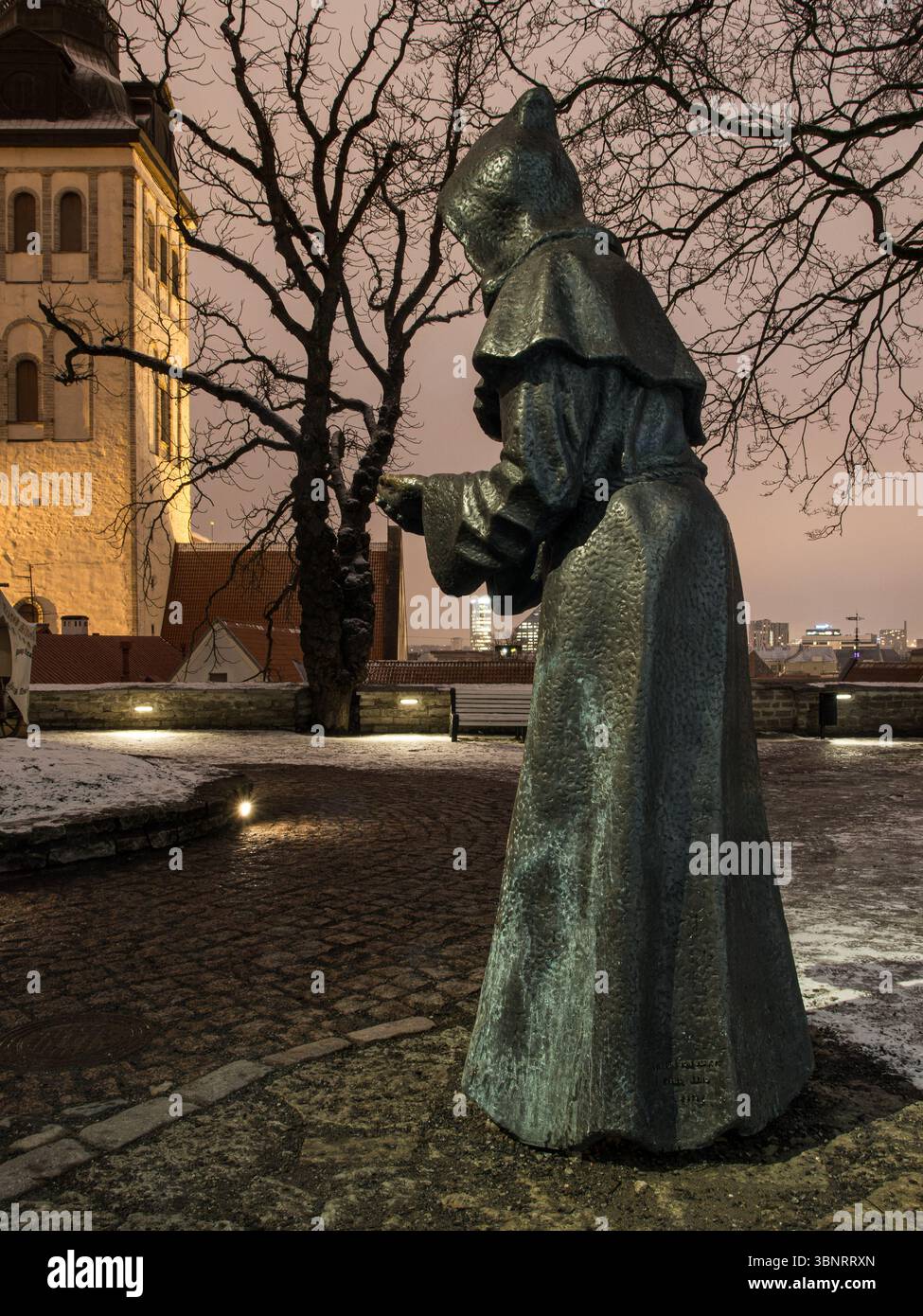 Bronze statue of medieval monk at night, St. Nicholas Church, Tallinn ...