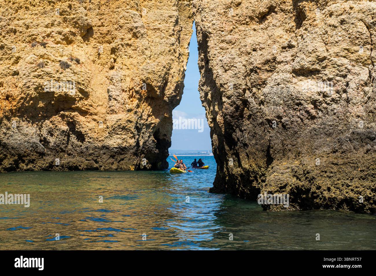 Kayakers exploring rocky cliffs and caves, Lagos, Algarve, Portugal ...