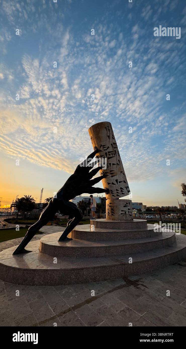 A dramatic sunset highlights an Iraqi monument, where an artistic ...