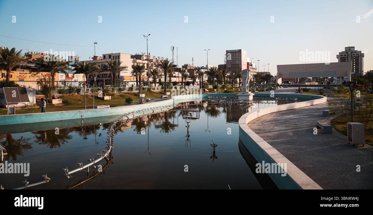 Visitors enjoy a sunny day at a park featuring a serene water body ...