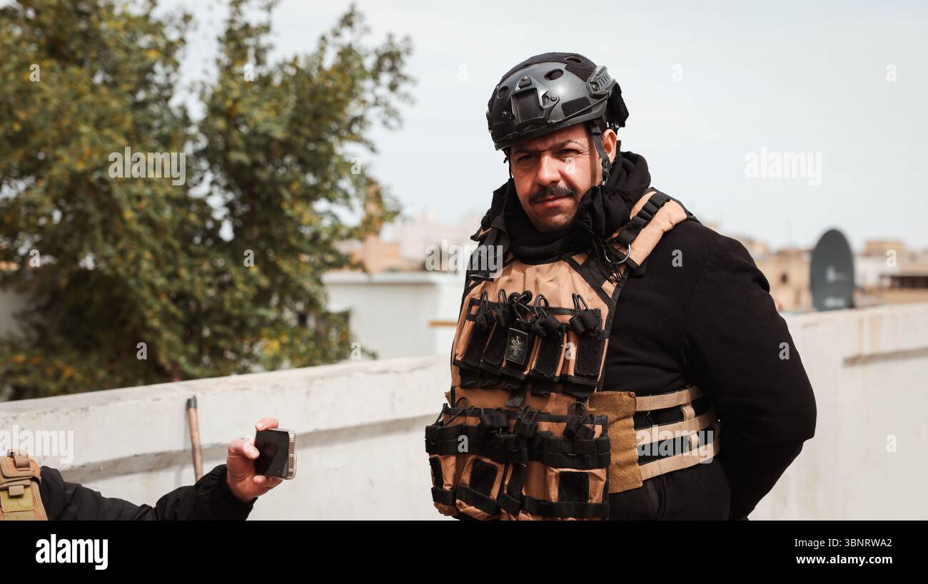 In Baghdad Iraq, a soldier in tactical gear stands alert, preparing for ...