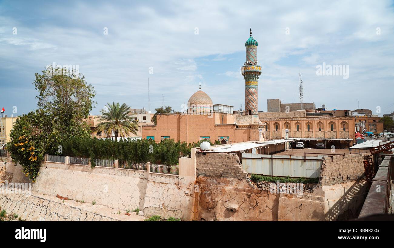 Traditional buildings and a striking mosque tower rise against the ...