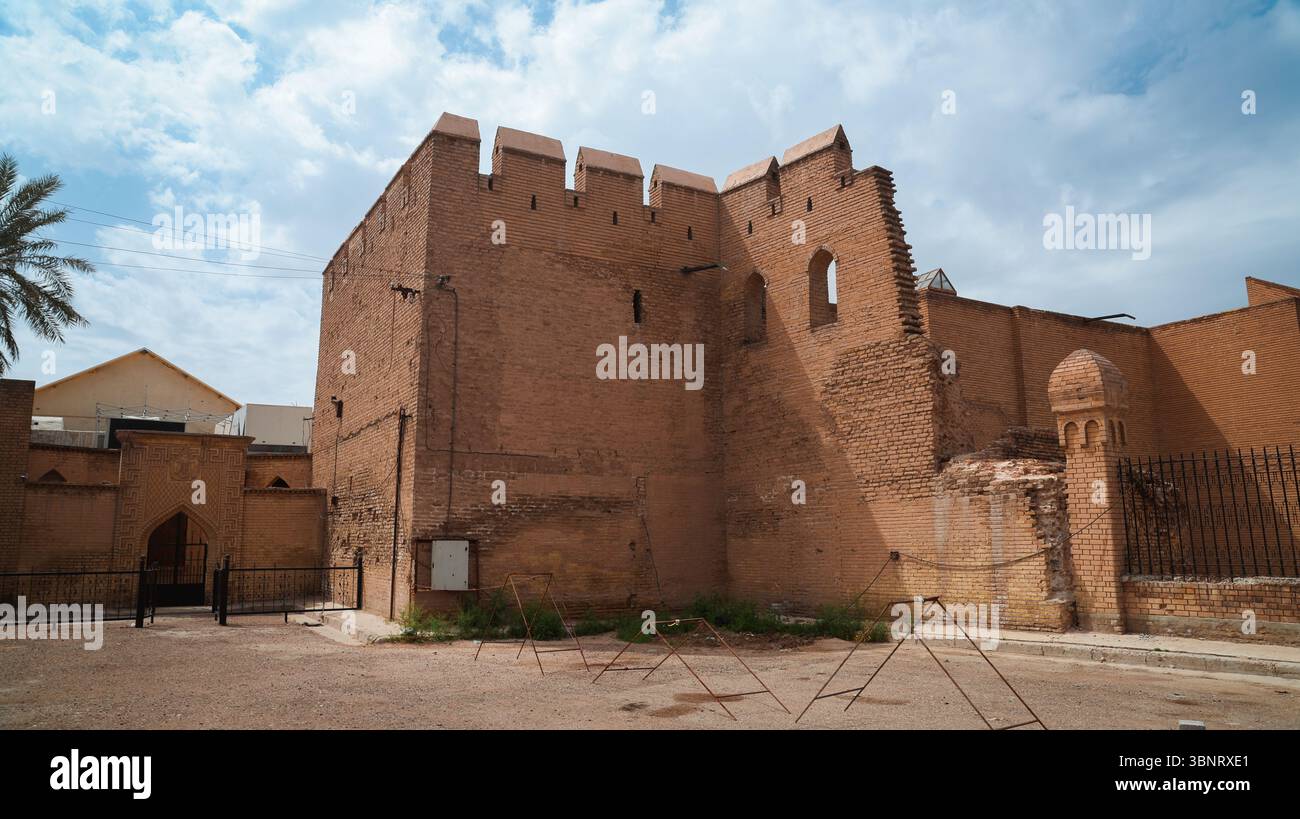 A historic brick building stands in Baghdad, Iraq under a cloudy sky ...