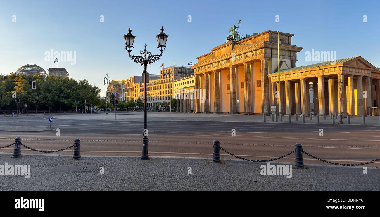 Brandenburg Gate in Berlin, bathed in golden light with empty streets ...