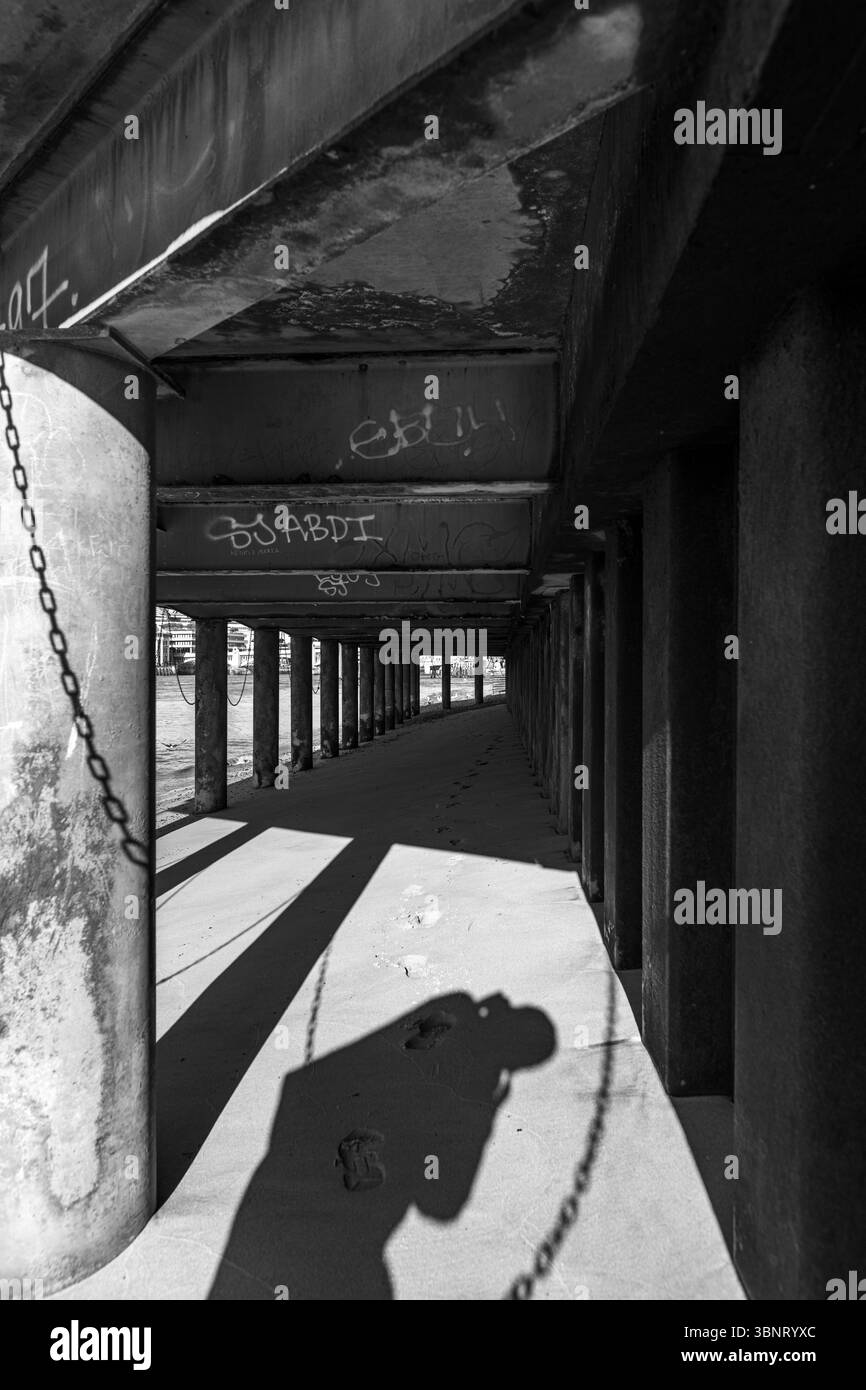 United Kingdom, London, 09 Jul 2025. View under a riverside walkway ...