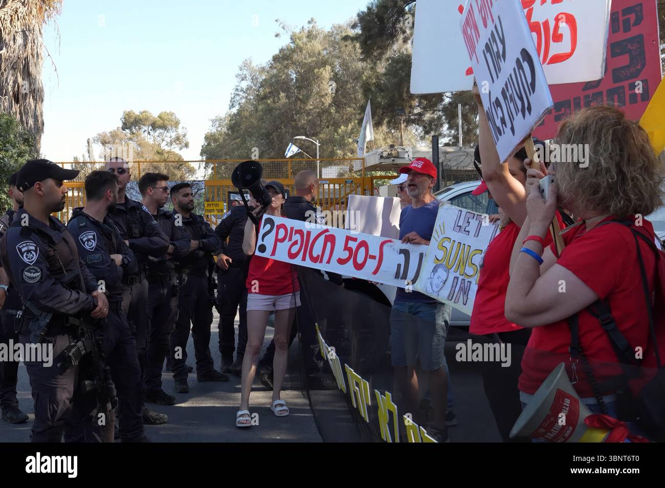 NIR OZ, ISRAEL - JULY 3: Police officers stand guard as protesters hold ...