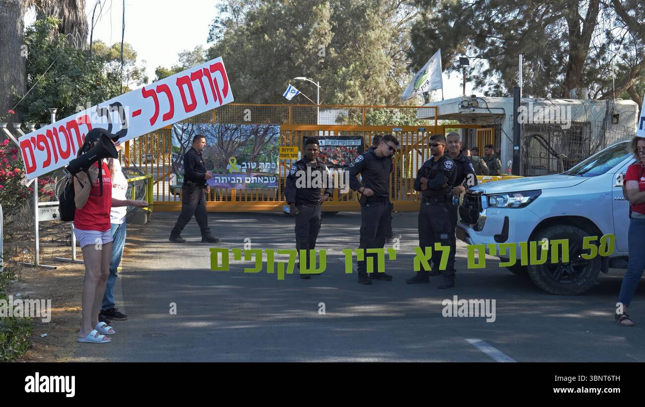 NIR OZ, ISRAEL - JULY 3: Police officers stand guard as protesters hold ...