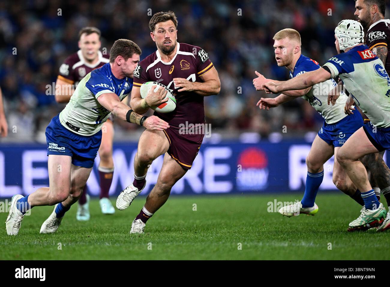 Tyson Smoothy of the Broncos is tackled by Harry Hayes of the Bulldogs ...