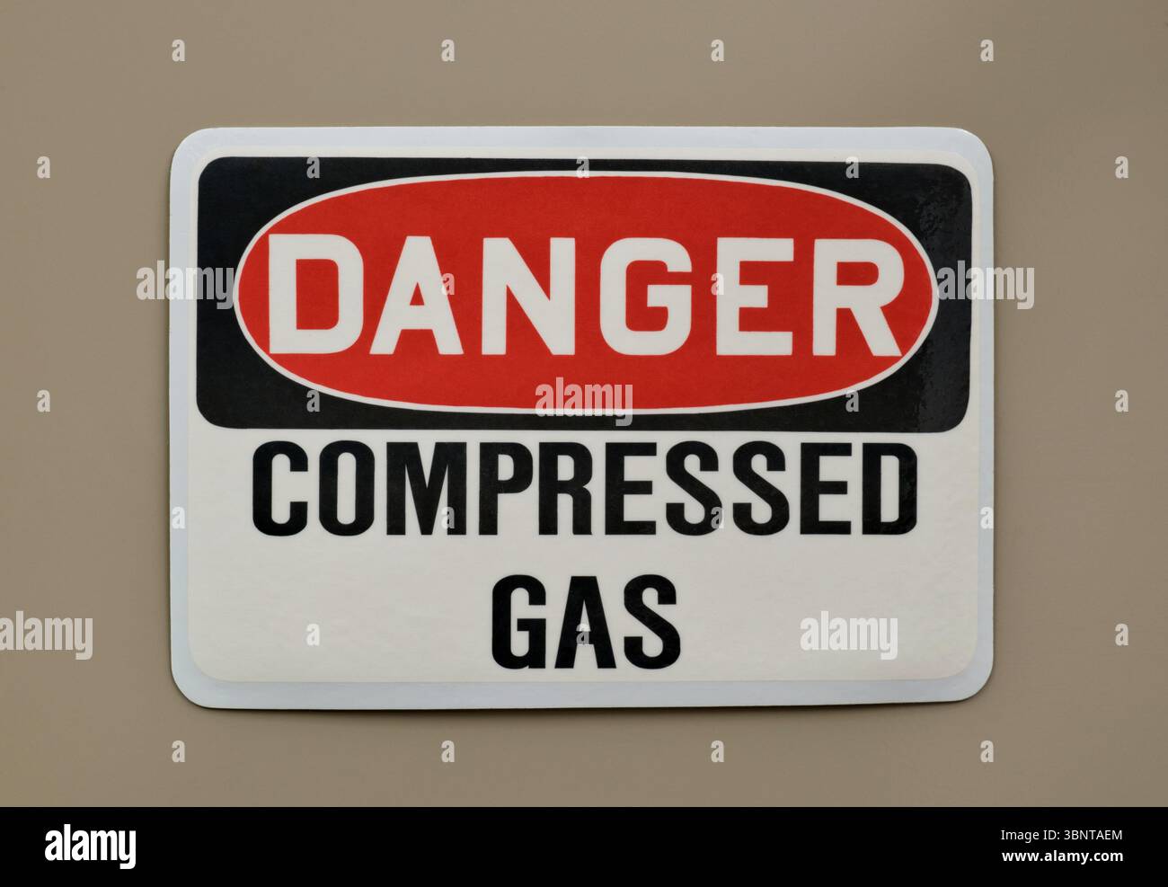 Danger Compressed Gas safety sign warning notice on wall industrial ...