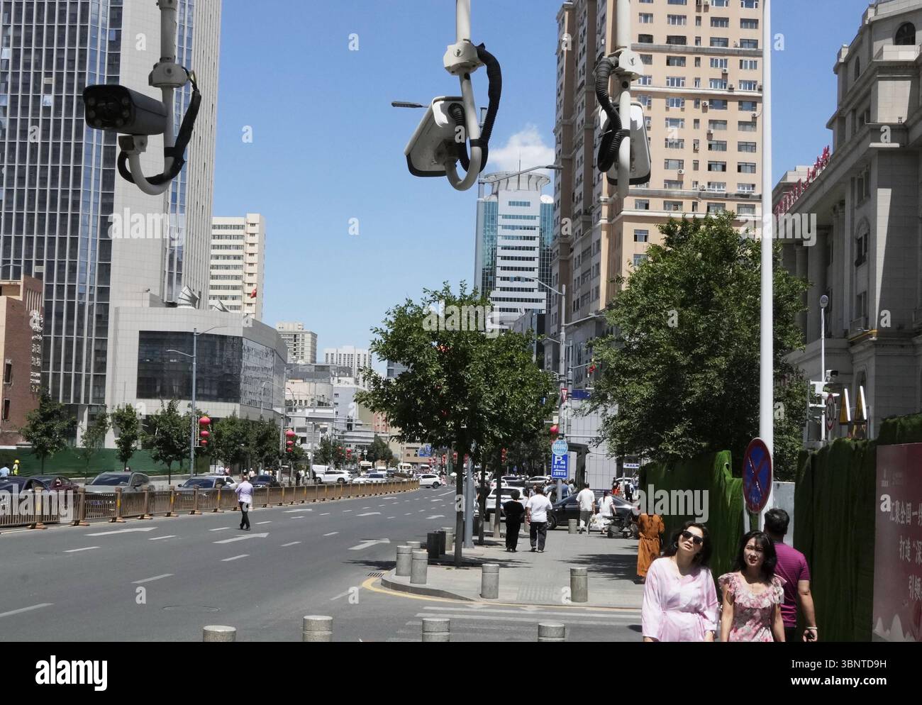 Surveillance cameras are installed above a street in Urumqi in China's ...