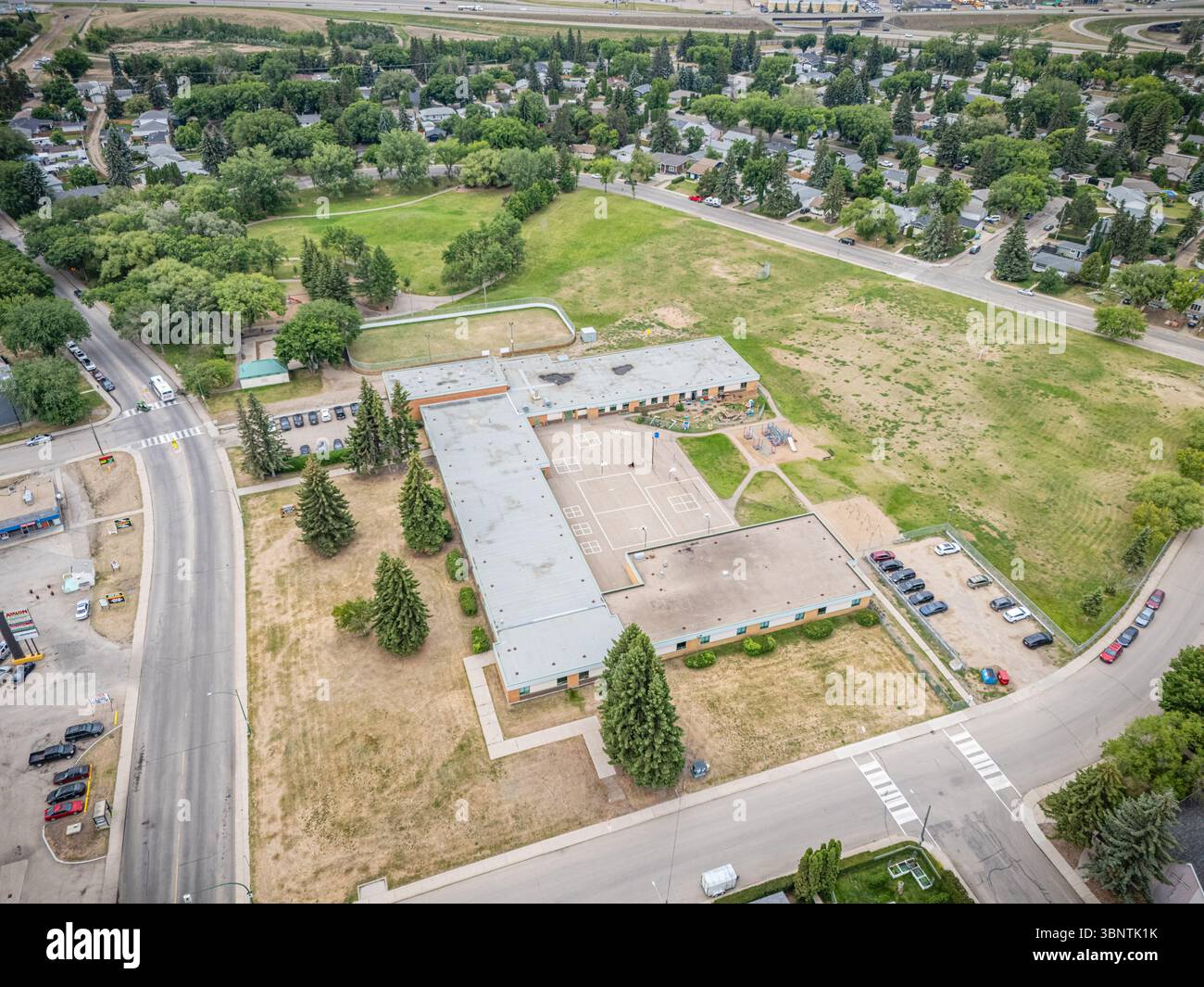 Large empty lot with a school building in the middle. The lot is ...
