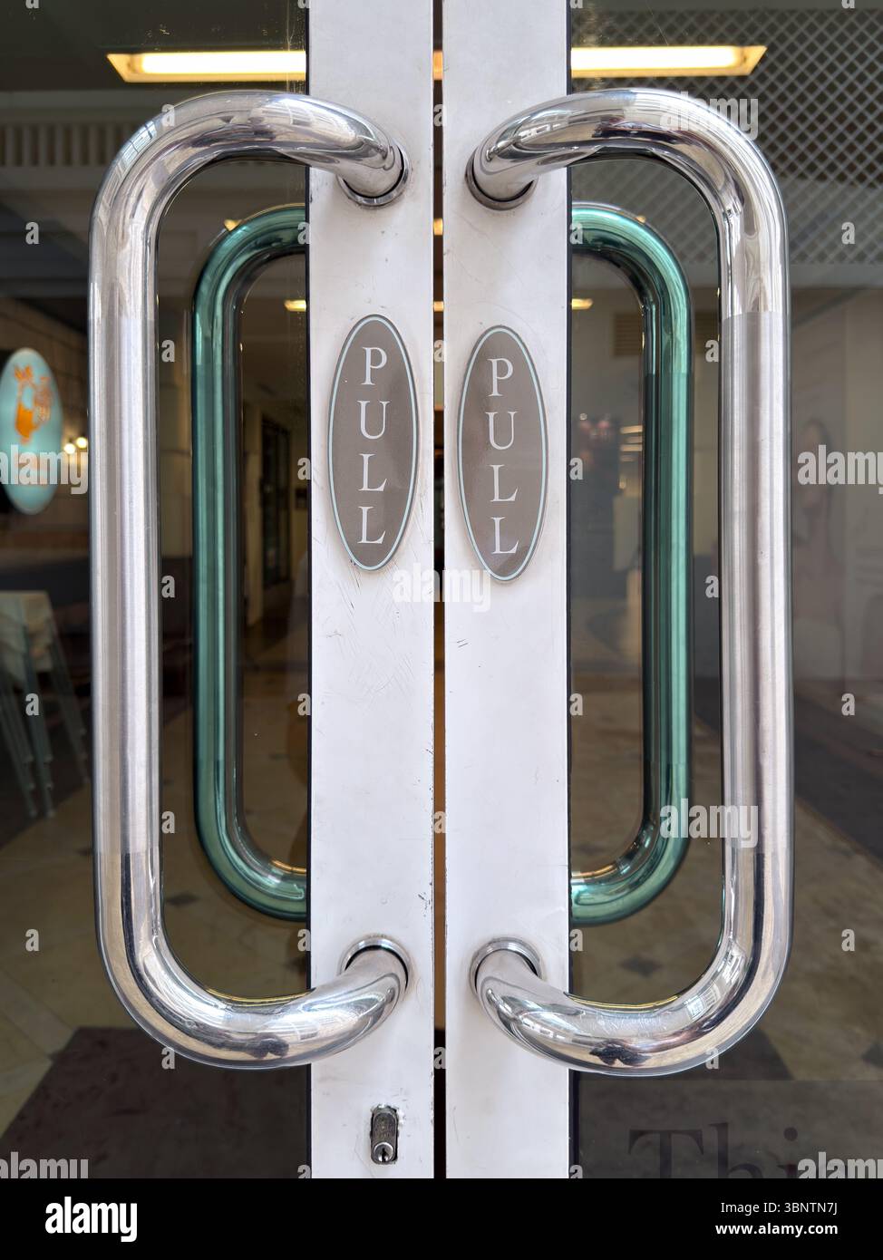 Double door handles with pull signs on glass entrance Stock Photo - Alamy