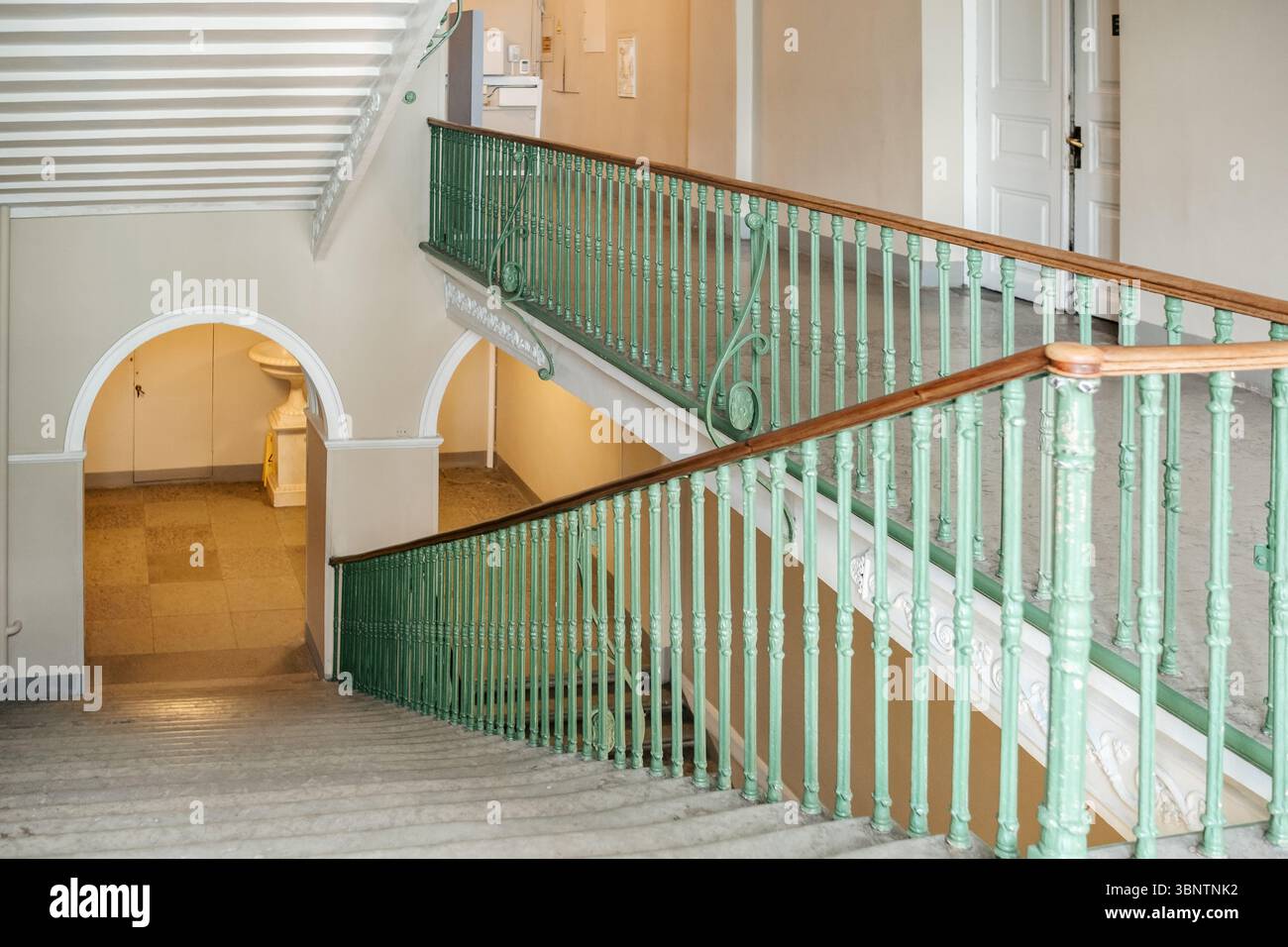 Elegant Green Stair Railing in a Historic Building Leading to an Arched ...