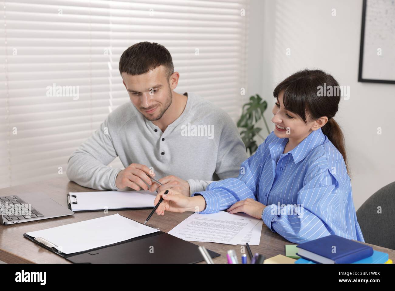 Consultant working with client at table in office. Business meeting ...