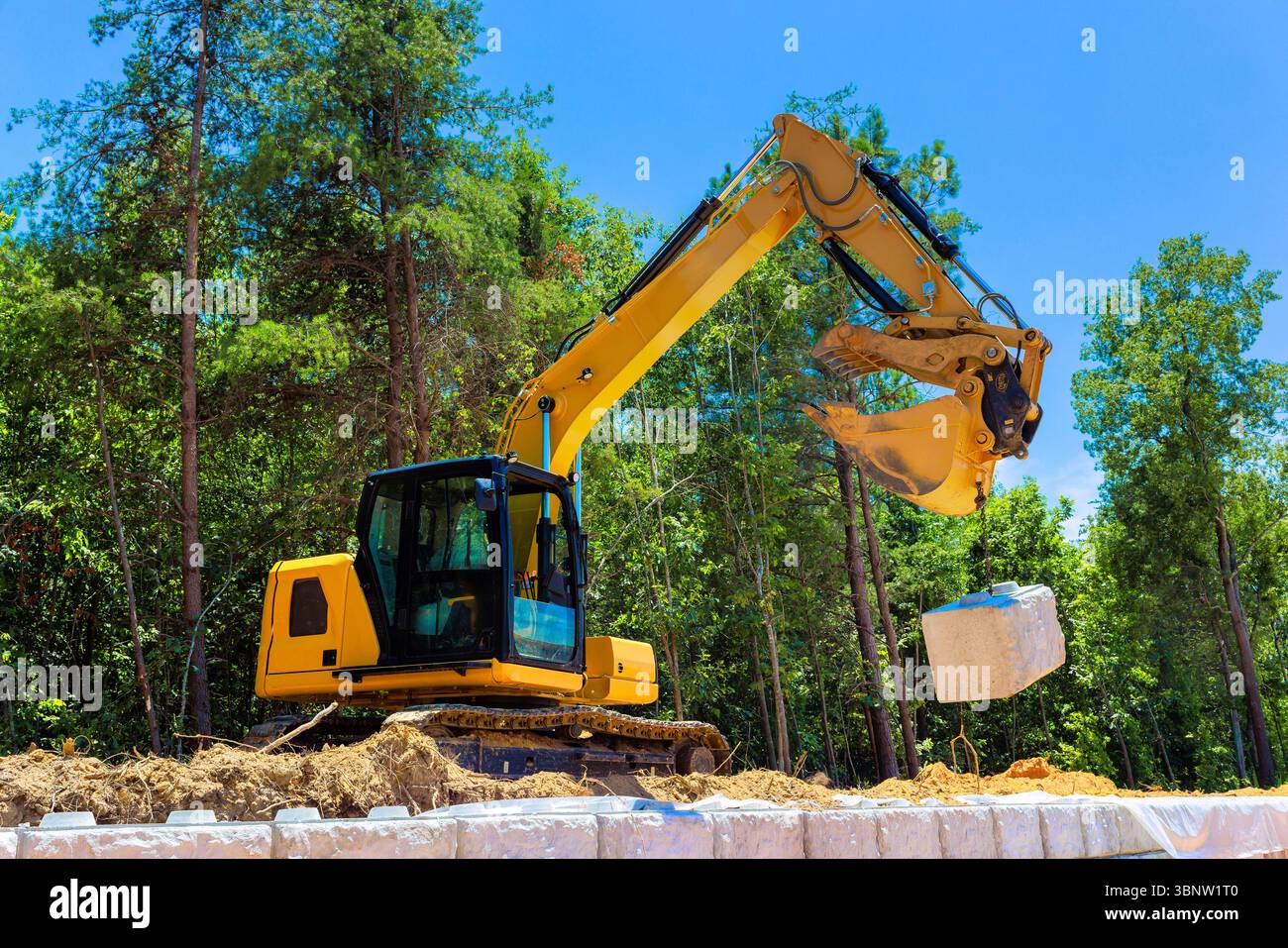 Heavy machinery is actively lifting large stone block during build ...