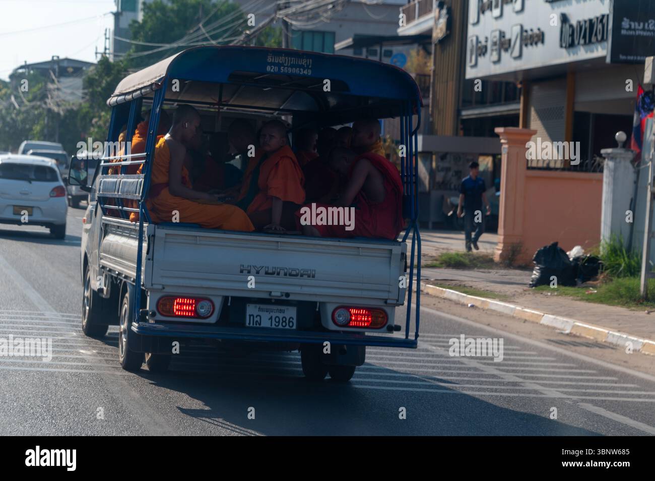 A pickup truck carrying a group of Buddhist orange clad monks in one of ...