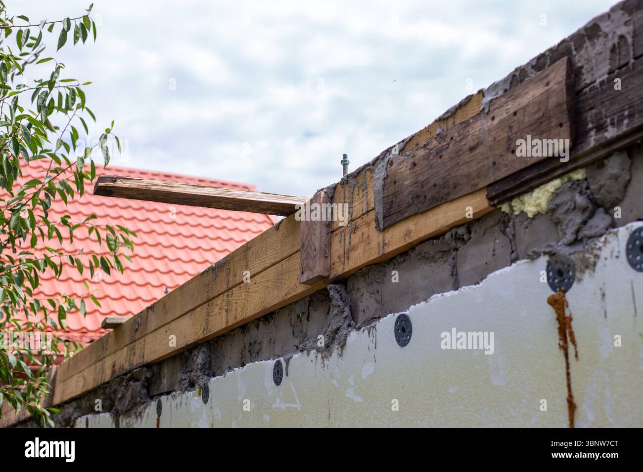 Concrete wall with wooden formwork on top, construction of reinforced ...