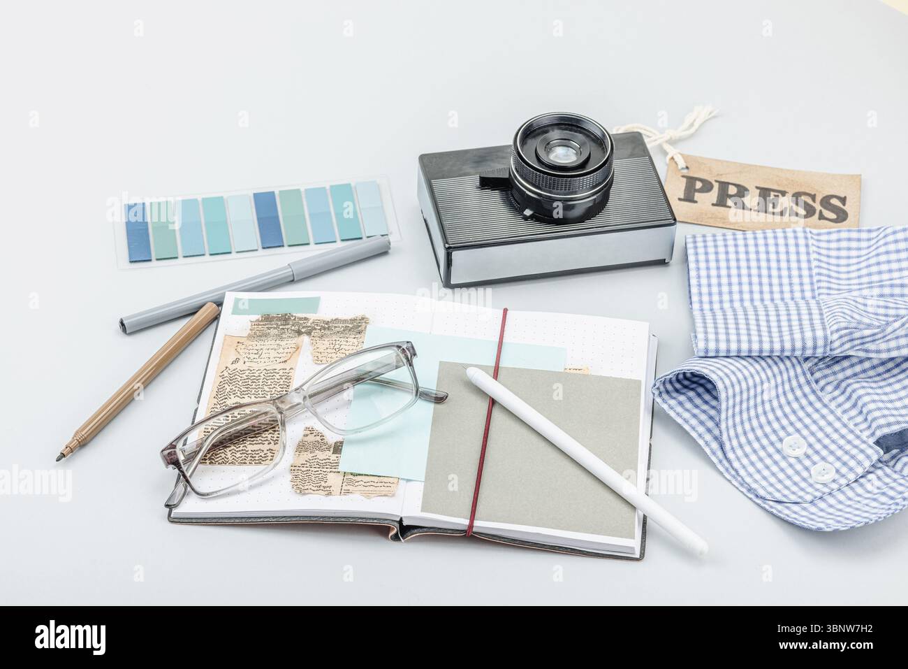 Flat lay of retro journalist essentials on blue background: camera ...