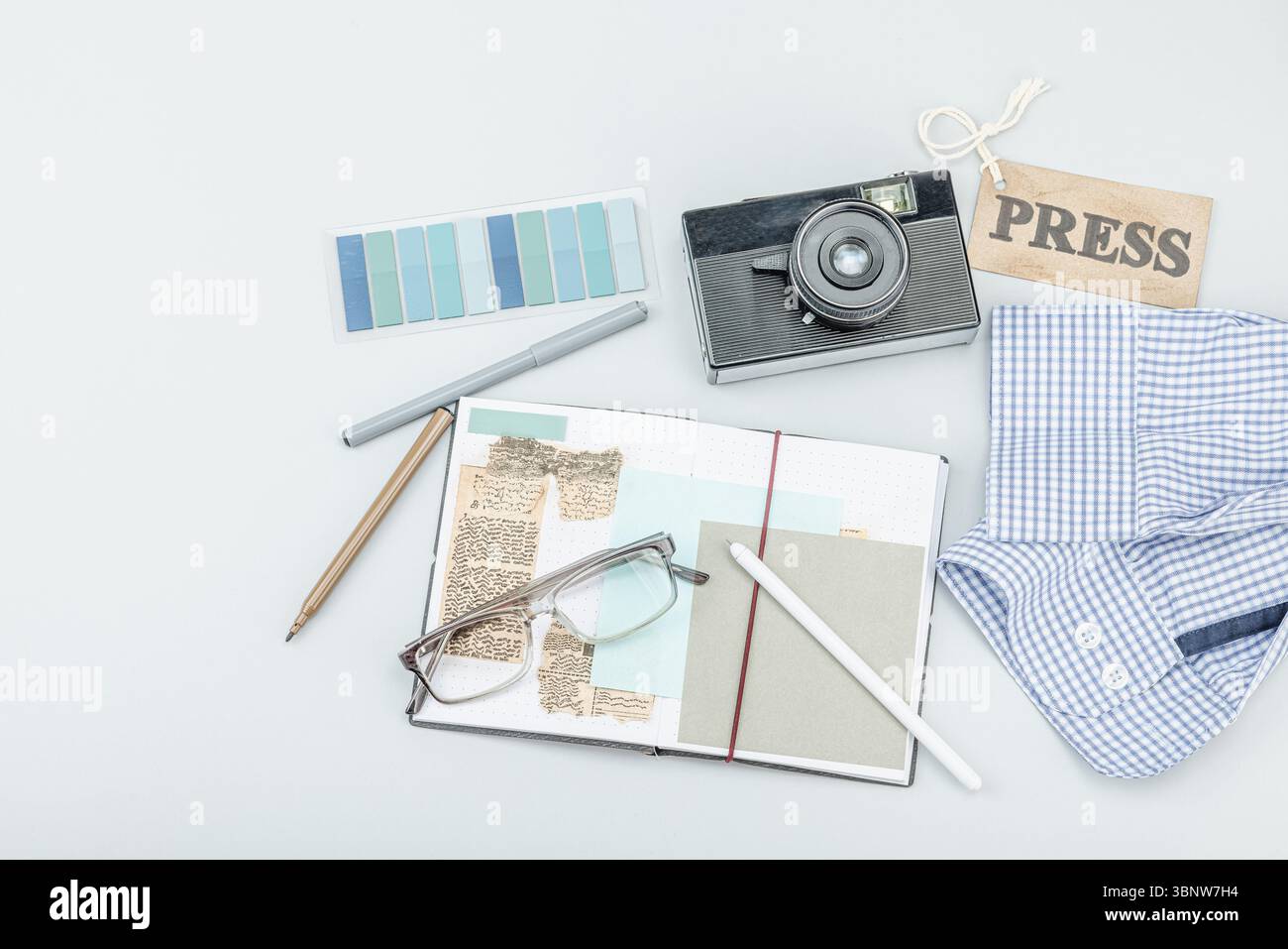 Flat lay of retro journalist essentials on blue background: camera ...